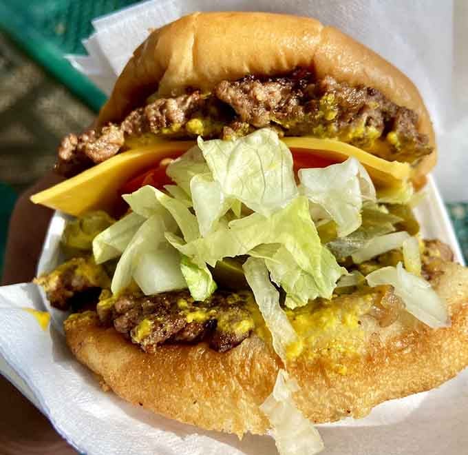 Look at those perfectly griddled patties with cheese melting into every crevice like liquid gold finding home.