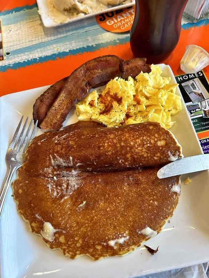 Pancakes so fluffy they practically float off the plate, accompanied by bacon and scrambled eggs done right.