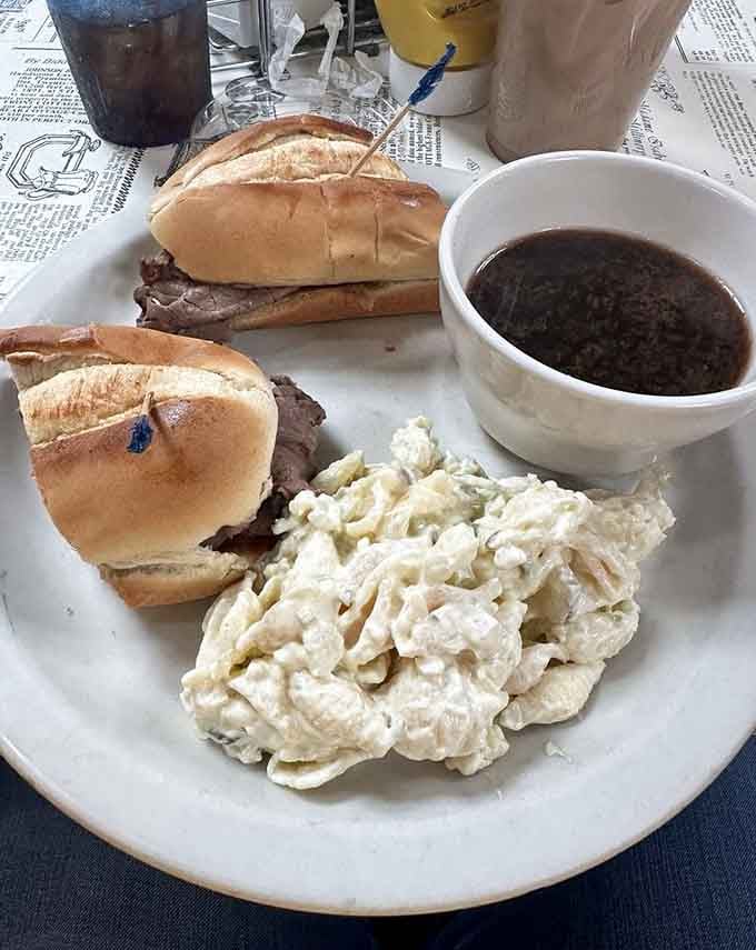 French dip sandwiches arrive with au jus for dunking, accompanied by coleslaw and comfort.