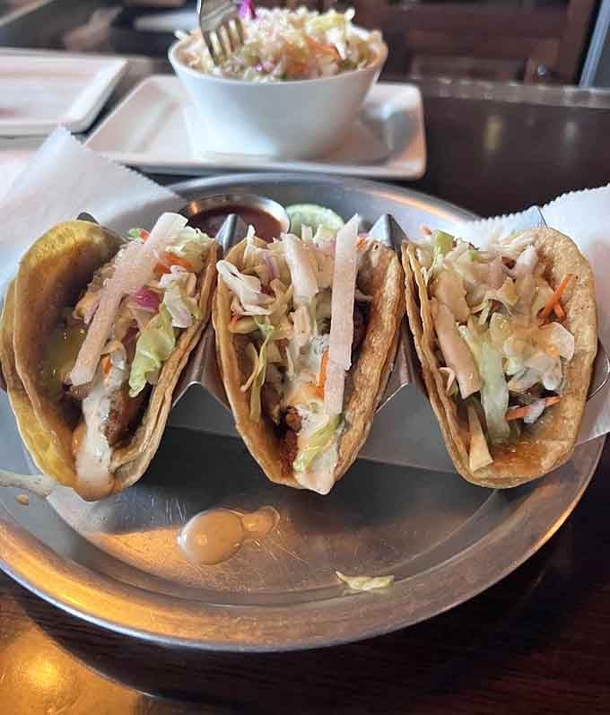 Three tacos lined up like soldiers ready for duty, each one packed with enough flavor to make you forget about Taco Tuesday.