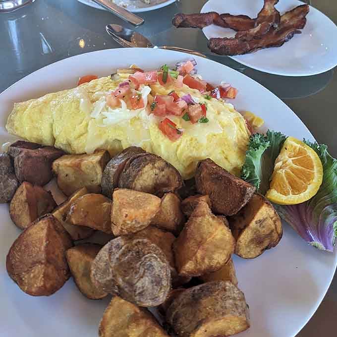 This omelet arrives looking like it just won the breakfast beauty pageant, and those crispy potatoes deserve their own award.