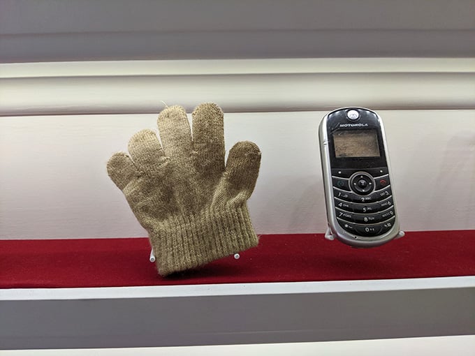 A worn glove and an old Motorola phone sit together like artifacts from a civilization we just left behind.