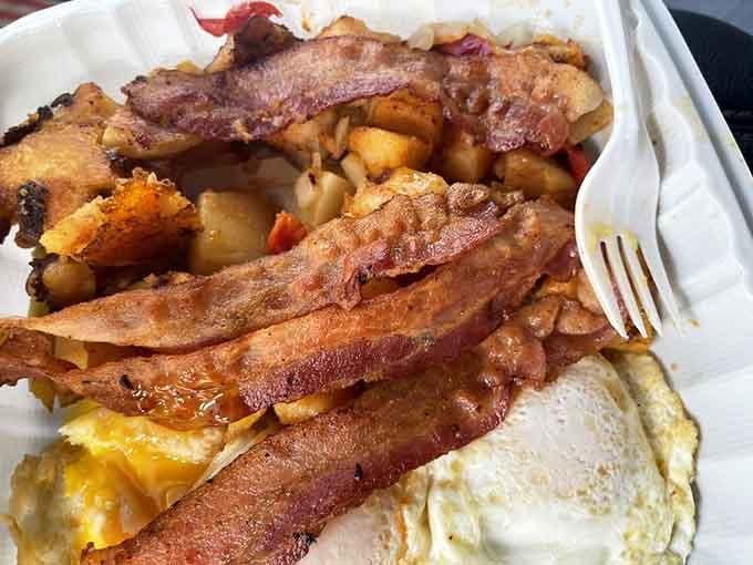 Bacon strips draped over eggs like a delicious blanket, because presentation matters even in humble diners.