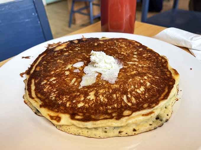 Golden blueberry pancakes topped with butter, proving that some mornings call for going big or going back to bed hungry.