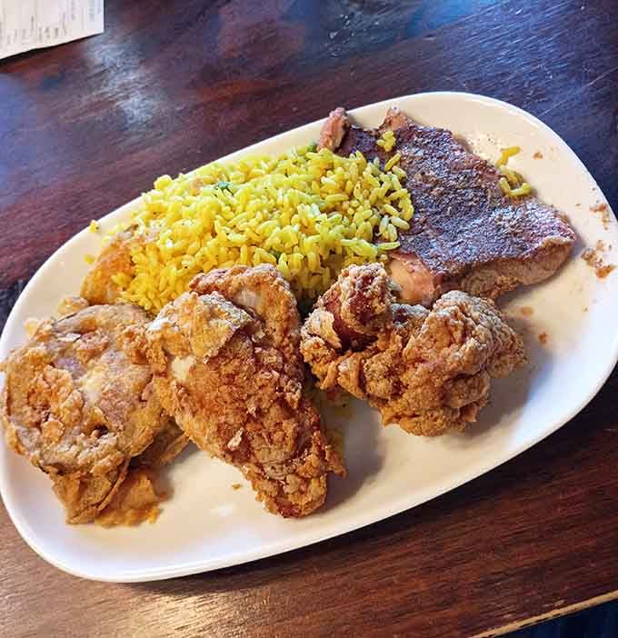 Golden fried chicken alongside seasoned rice and fish so perfectly cooked it practically melts on your fork.