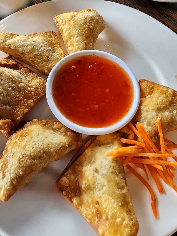 Crispy wontons stuffed with crab and cheese pair perfectly with sweet chili sauce for the ultimate starter course indulgence.