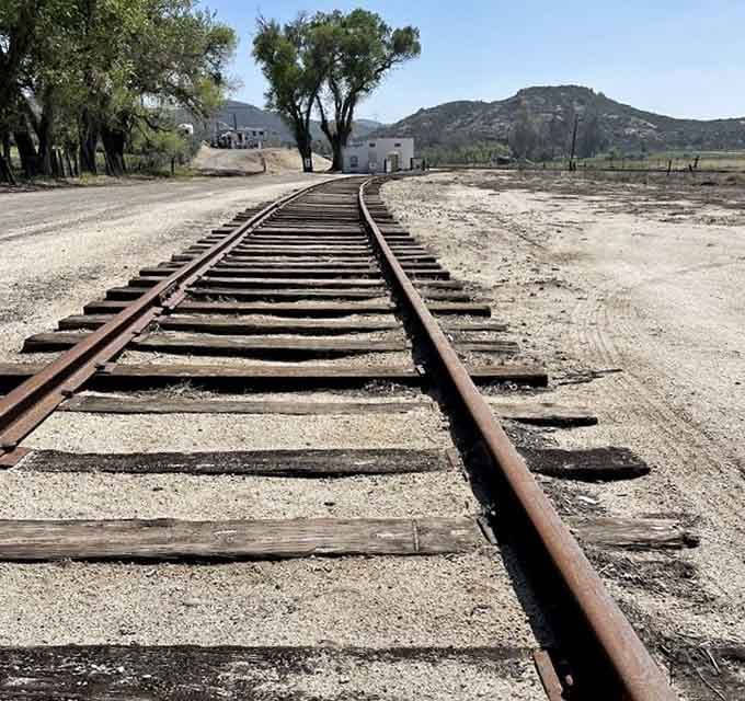 Rails stretching toward rolling hills remind you that sometimes the best destinations require the scenic route to get there.