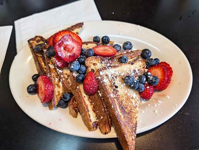 French toast adorned with berries like edible confetti celebrating your excellent decision to eat here today.