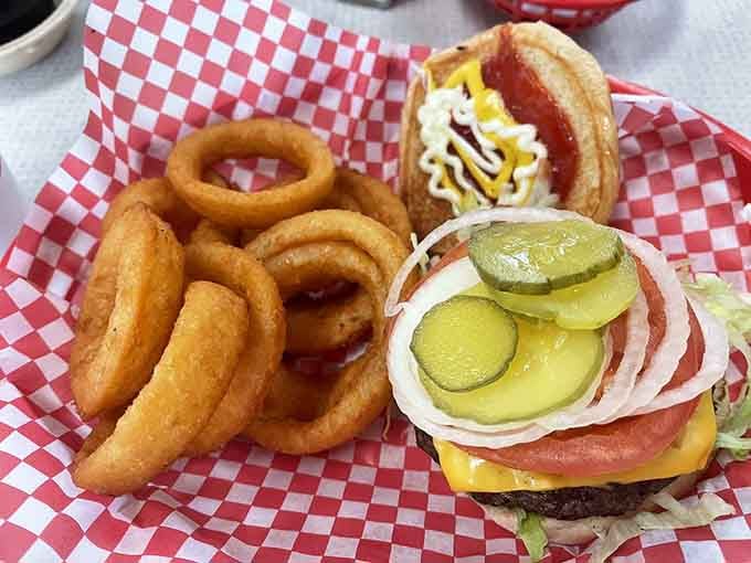 That burger comes with onion rings because apparently someone decided you needed both happiness and fried perfection on one plate.