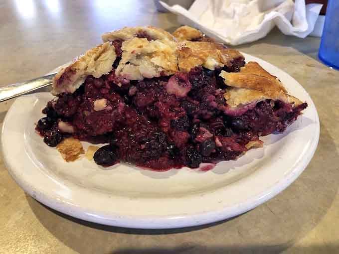 This triple berry pie bursting with fruit is like summer captured under a golden, buttery blanket of pastry.