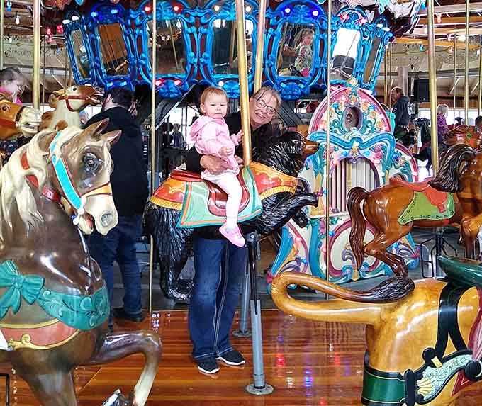 Dad's expression says he's definitely choosing the black stallion next round while his daughter claims the spotted pony.