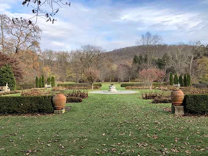 Terra cotta urns flanking manicured hedges because apparently someone here really understands dramatic garden entrances.