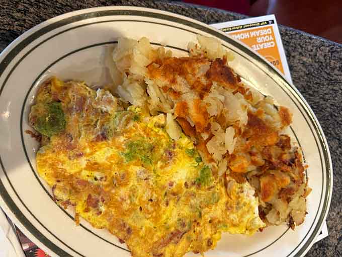That omelet looks like it's been hitting the gym, packed with vegetables and melted cheese perfection.