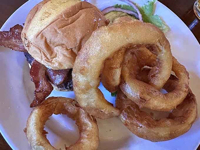 Beer-battered onion rings so perfectly golden they could moonlight as edible jewelry for carb enthusiasts everywhere.