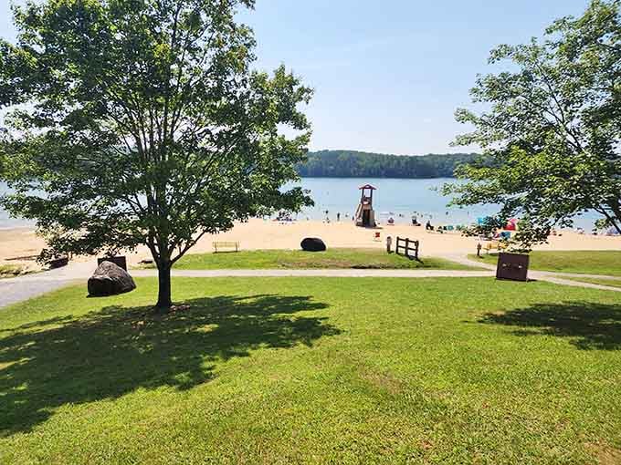 This vibrant scene perfectly captures a sunny day as beachgoers relax, swim, and soak up sunshine, embracing the beautiful waterfront atmosphere together.