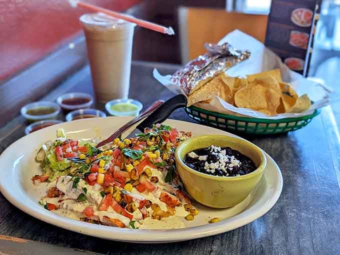 Pollo con queso draped in creamy sauce with colorful toppings that taste even better than they look on the plate.