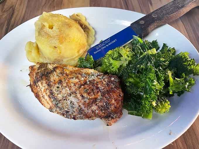 Perfectly seasoned chicken breast with roasted potatoes and greens, because sometimes simple preparation showcases quality ingredients best.