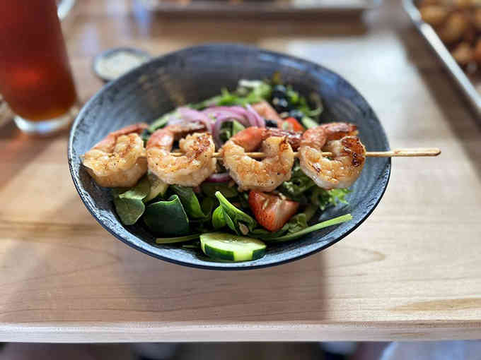 Grilled shrimp perched atop fresh greens like they're posing for their close-up, and honestly, they've earned it.