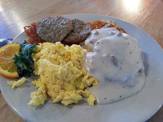This plate showcases the full breakfast experience: fluffy eggs, crispy hash browns, and gravy-smothered biscuits working in perfect harmony.