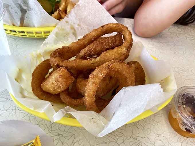 These golden onion rings stack up like edible architecture, crispy circles of pure fried happiness in a basket.
