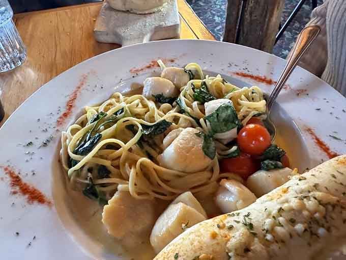 Scallops nestled in pasta like they're attending the most delicious dinner party you've ever been invited to.