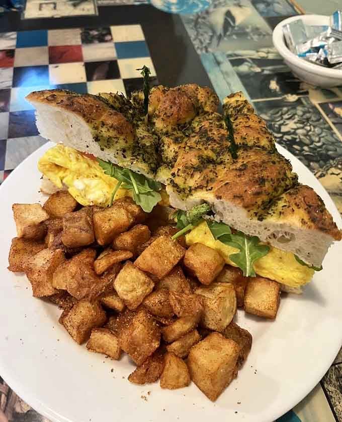 Focaccia bread stacked high with eggs and greens, because sometimes breakfast needs to think outside the traditional box.