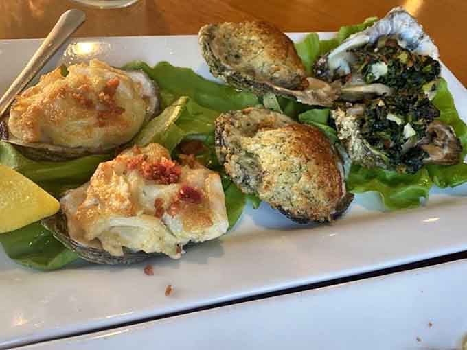 Three baked oysters showcasing different preparations, because why settle for one delicious option when you can have a trio of treasures?