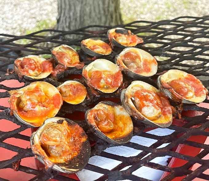 Fresh clams roasted over wood fire until they pop open, revealing tender treasures that taste like the ocean's greatest hits.