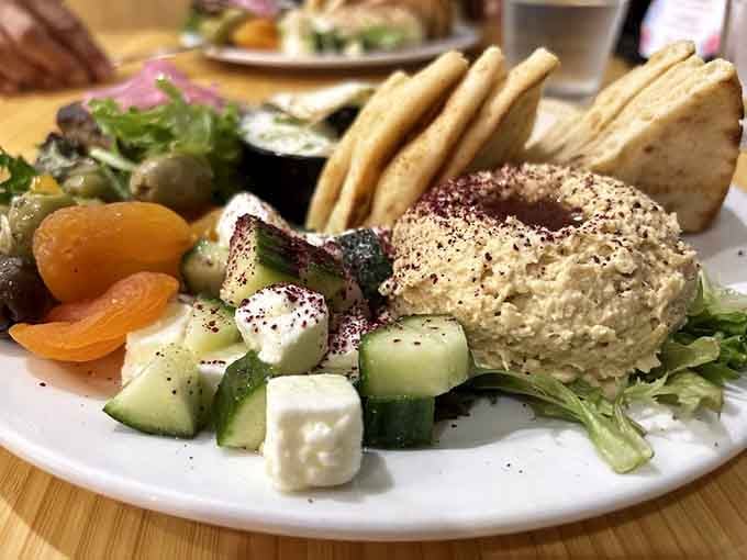 Turkish Breakfast brings Mediterranean sunshine to your table with hummus, fresh veggies, and pita for perfect sharing moments.