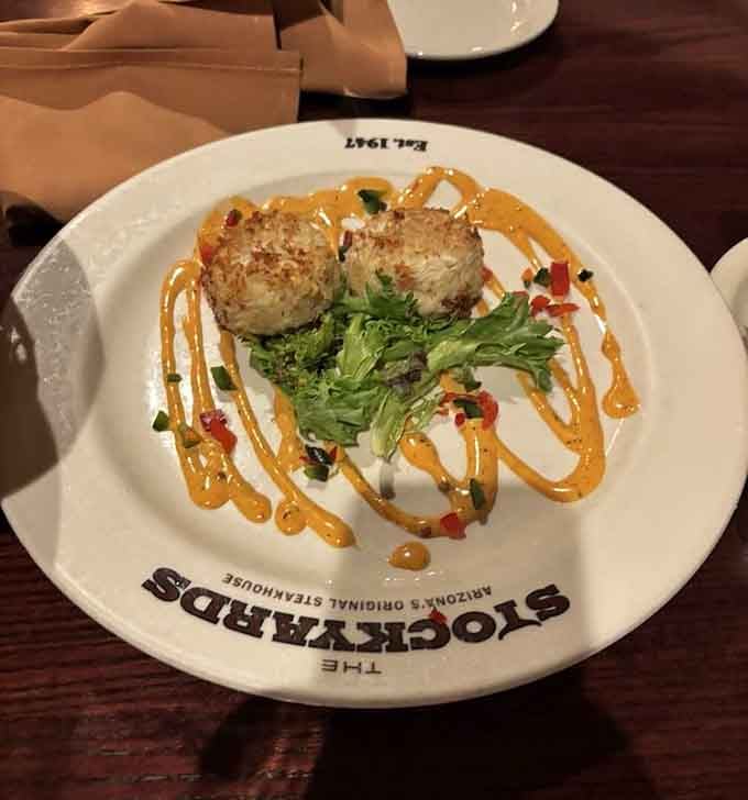 Golden-crusted crab cakes with that artistic drizzle prove seafood gets the same respect as beef at this establishment.