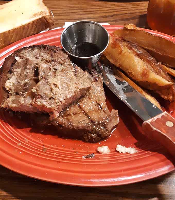 Prime rib paired with golden potato wedges on that signature red plate means business, delicious business.