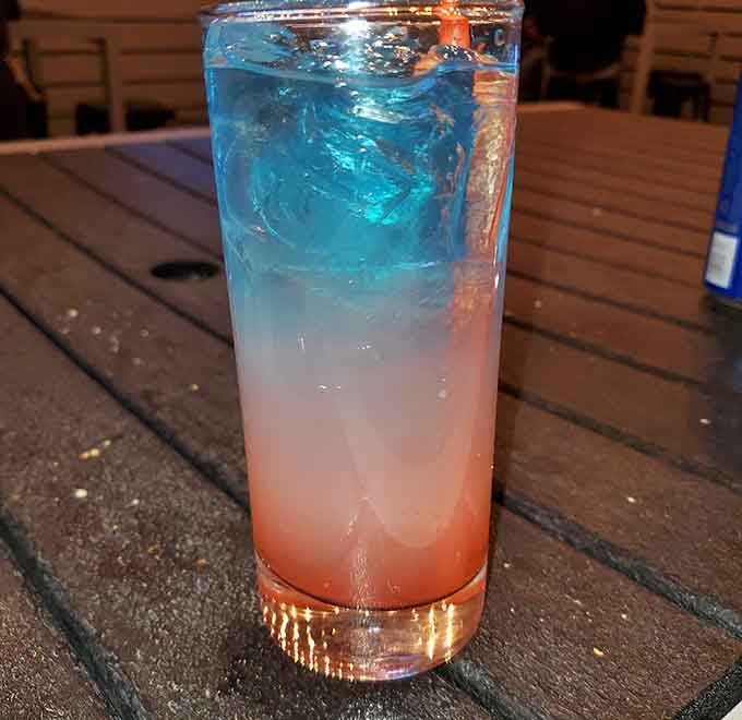 This gradient cocktail transitions from pink to blue like it's trying to match the arcade's color scheme, and honestly, respect.