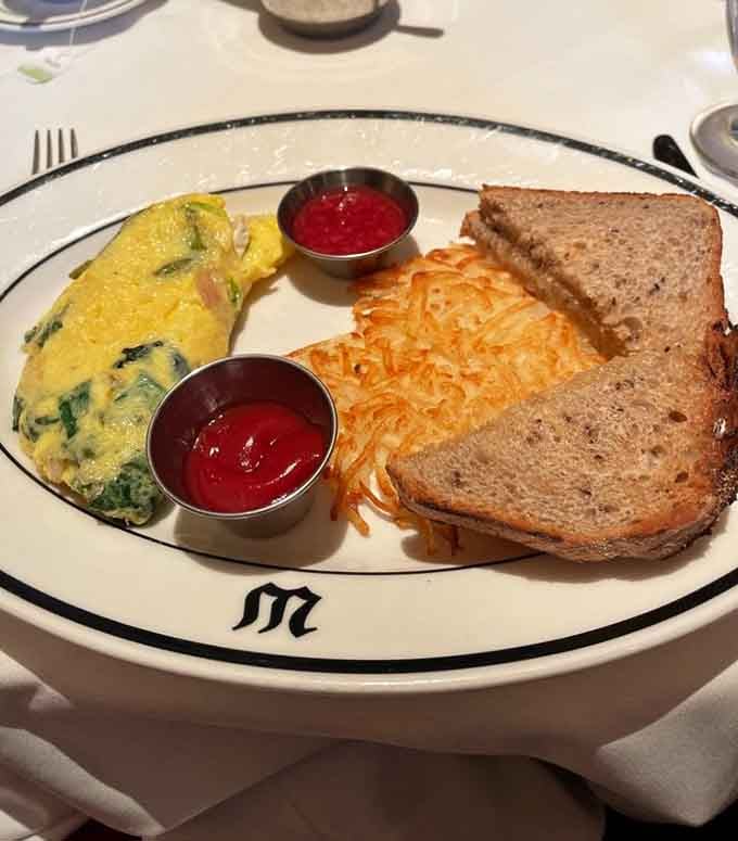 This omelet looks fluffier than a cloud and twice as satisfying, served with crispy hash browns perfection.