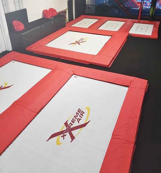 Two kids contemplating their next jump into the foam abyss, living their best trampoline park life in matching socks.