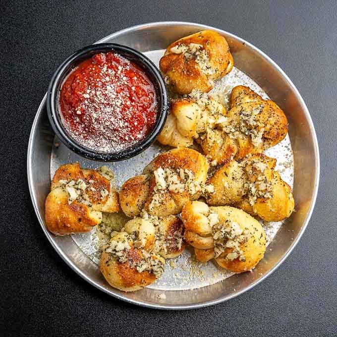 Garlic knots dusted with parmesan and herbs, because sometimes simplicity is the ultimate sophistication in Italian cooking.