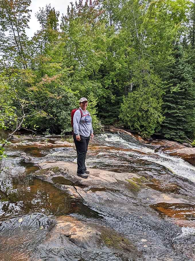 Standing on ancient rock while water rushes past, contemplating life or possibly just what's for dinner later.