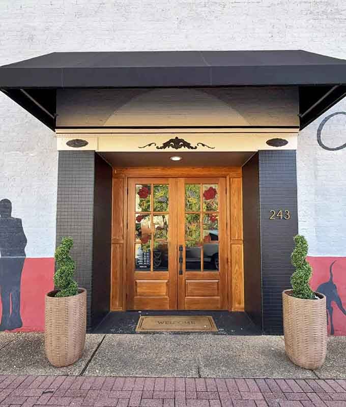 Those elegant wooden doors framed by modern black awnings create an inviting entrance to downtown steak perfection.