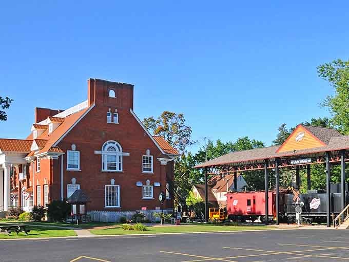 Bright red brick meets railroad history where vintage cabooses remind us that adventure once arrived on iron rails and steam.