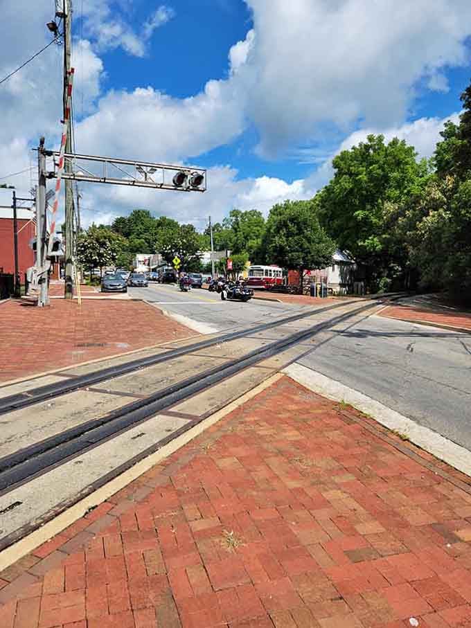 Railroad crossing signals stand guard over brick streets that have welcomed travelers for over a century.