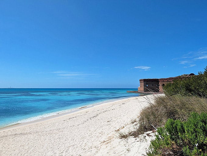 Pristine white sand meets impossibly blue water at this remote beach where the historic fort stands guard silently.
