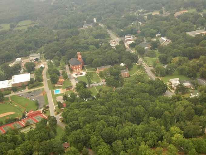 Bird's-eye view reveals a college town nestled in green forests like a hidden treasure.