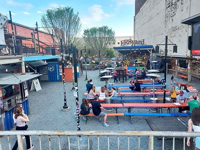 Colorful picnic tables fill this open-air food hall where shipping containers house diverse vendors serving everything your hungry heart desires.