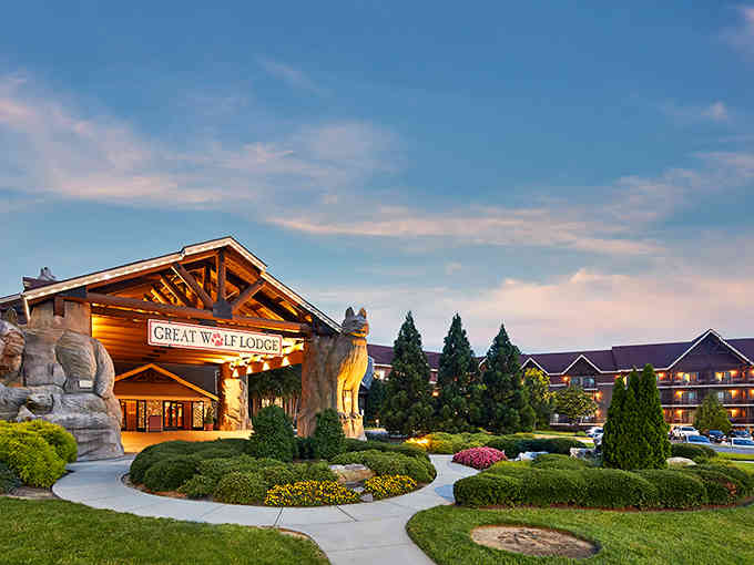 The grand lodge entrance glows at dusk, promising cozy adventures and indoor water fun year-round.