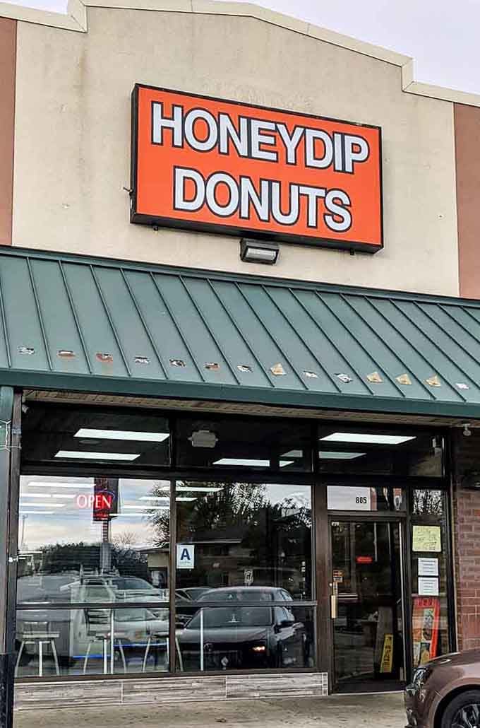 That bold orange sign against the cream exterior is impossible to miss&mdash;like a beacon calling all donut enthusiasts home.