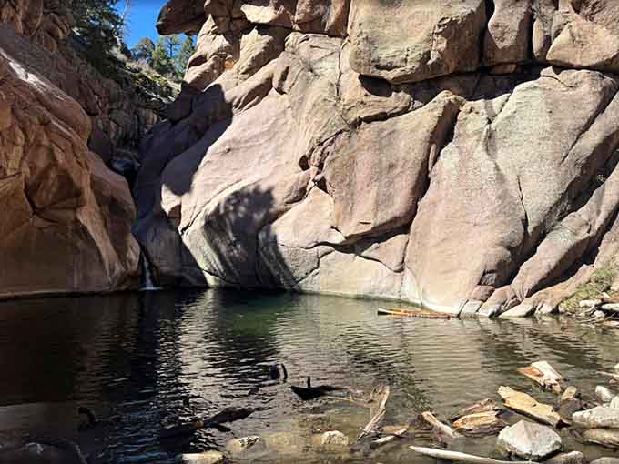 Smooth canyon walls cradle this hidden swimming hole where clear water pools between ancient rocks, nature's private oasis waiting.