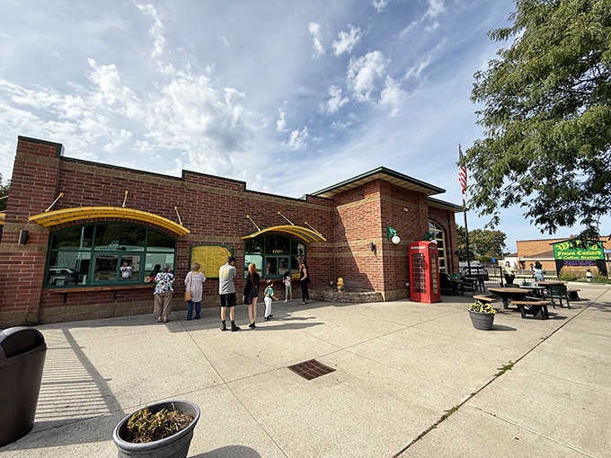 Those cheerful yellow awnings and red British phone booth create an unexpectedly delightful backdrop for frozen custard dreams.