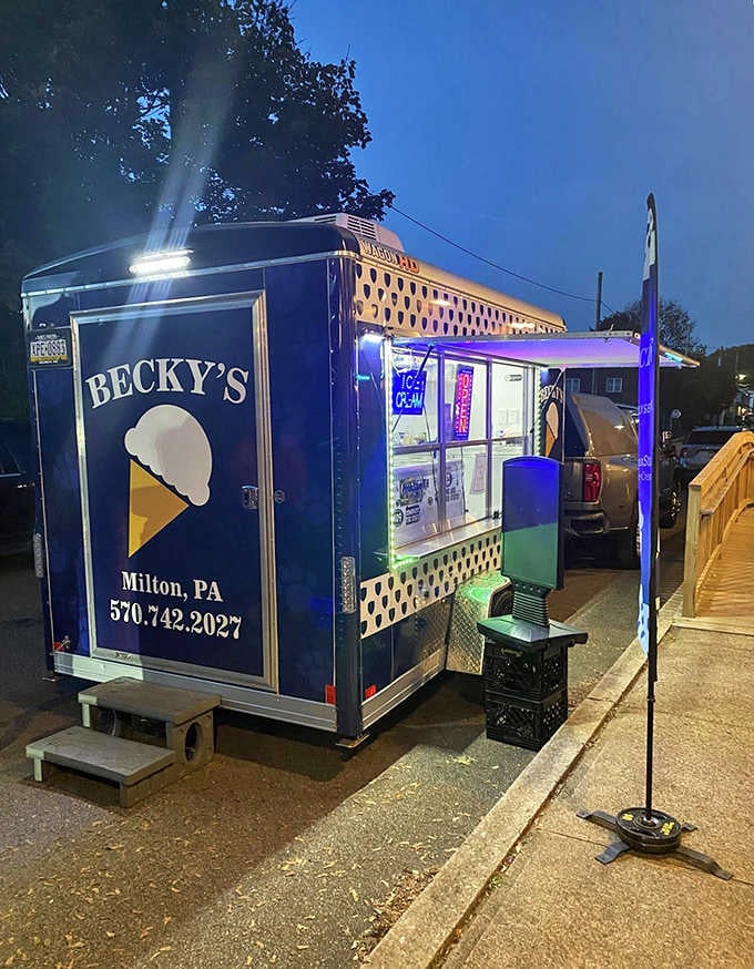 The blue trailer gleams under evening lights, proving great ice cream doesn't need fancy buildings to shine.