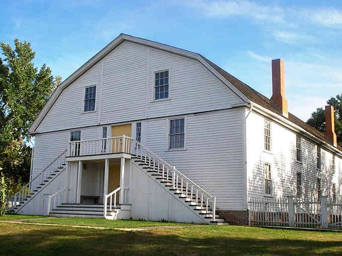 The communal building's clean lines and external staircase tell stories of immigrants who built something lasting from scratch.