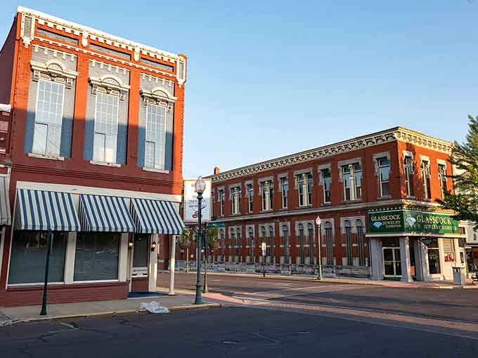 Early morning light bathes the empty street in golden warmth, before shopkeepers unlock doors and the day begins.