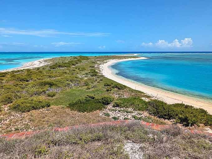 The island curves gracefully between two shades of turquoise, offering untouched beauty that rewards the adventurous journey out.